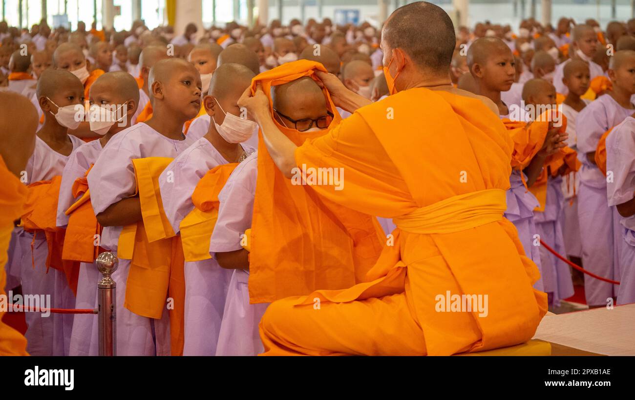 Devotees take part in the mass ordination ceremony at Wat Phra ...