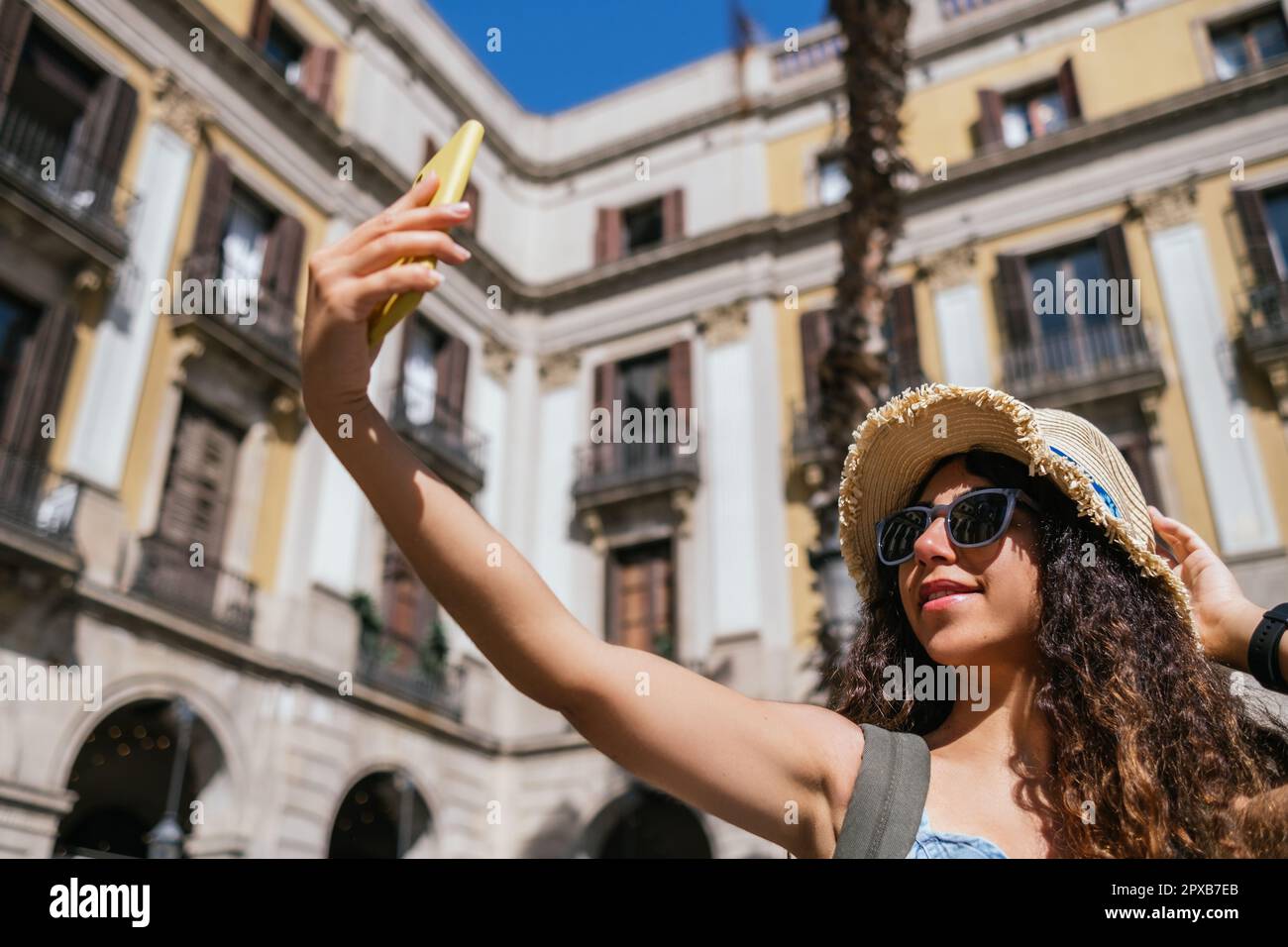 young indian female tourist wearing a straw hat and sunglasses taking a ...
