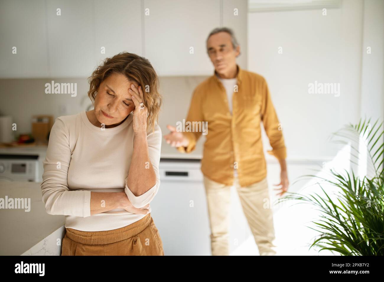 Upset senior woman crying in kitchen while arguing with husband, angry ...