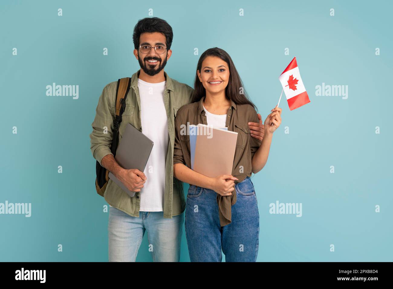 Cheerful multicultural man and woman with Canadian flag, blue ...