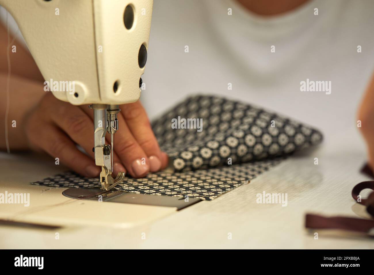 girl seamstress sew on the sewing machine. Women's hands sewing on the ...