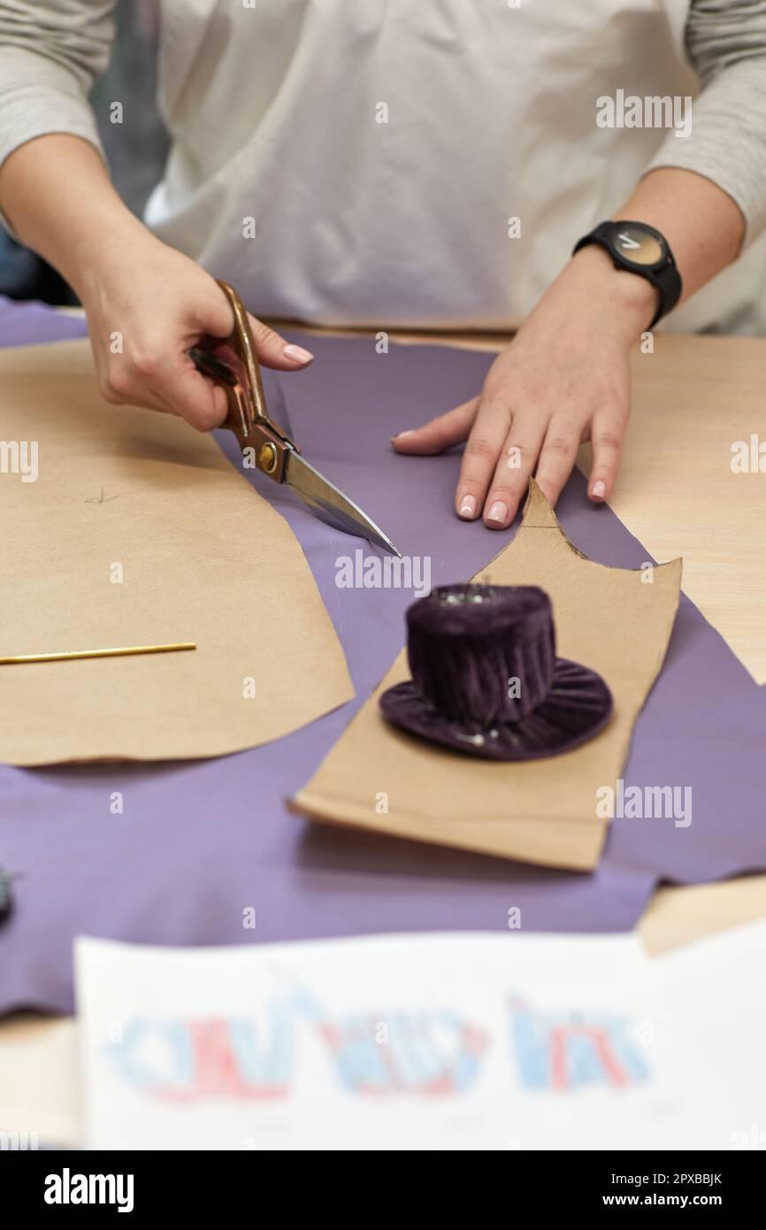 Workplace of seamstress. Dressmaker cuts textile on the sketch lines ...
