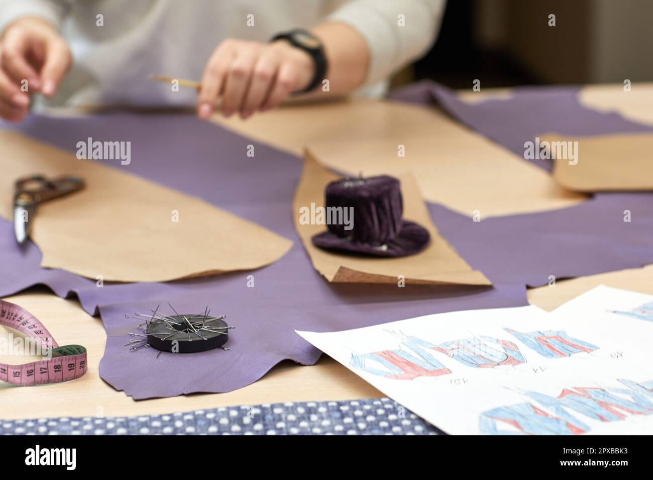 Workplace of seamstress. Dressmaker cuts textile on the sketch lines ...