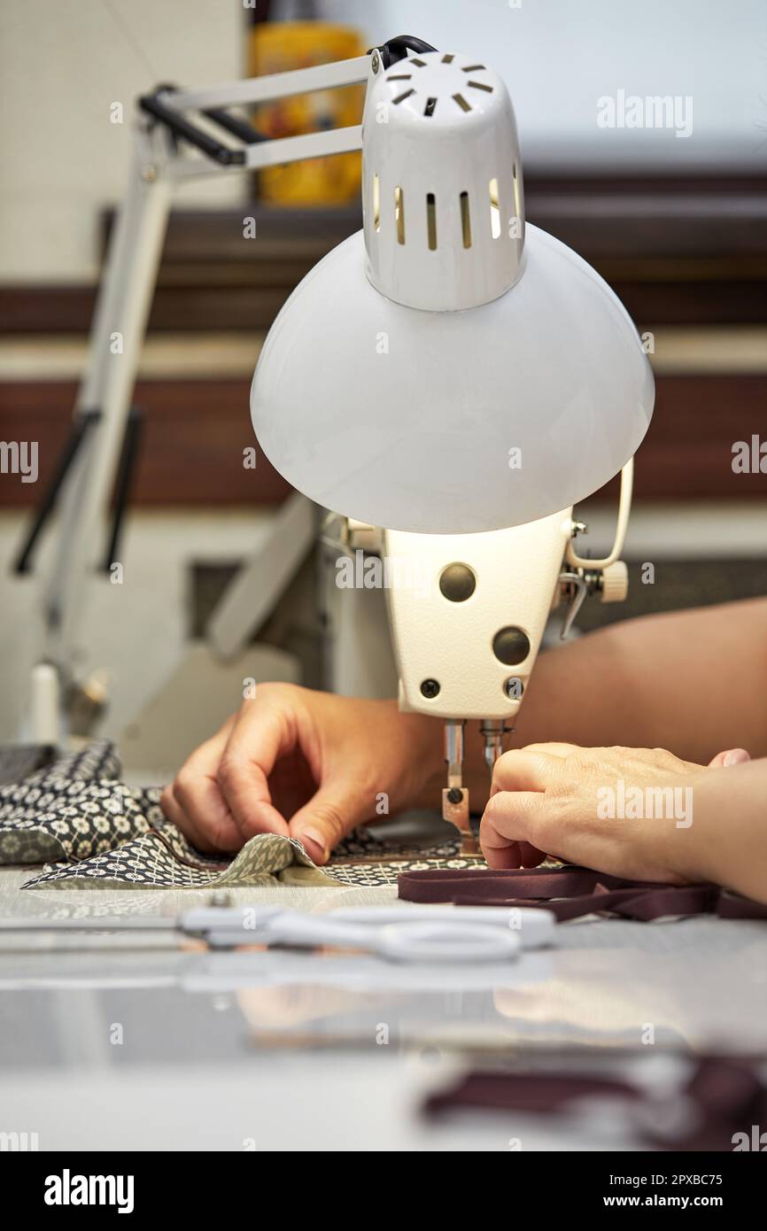 girl seamstress sew on the sewing machine. Women's hands sewing on the ...