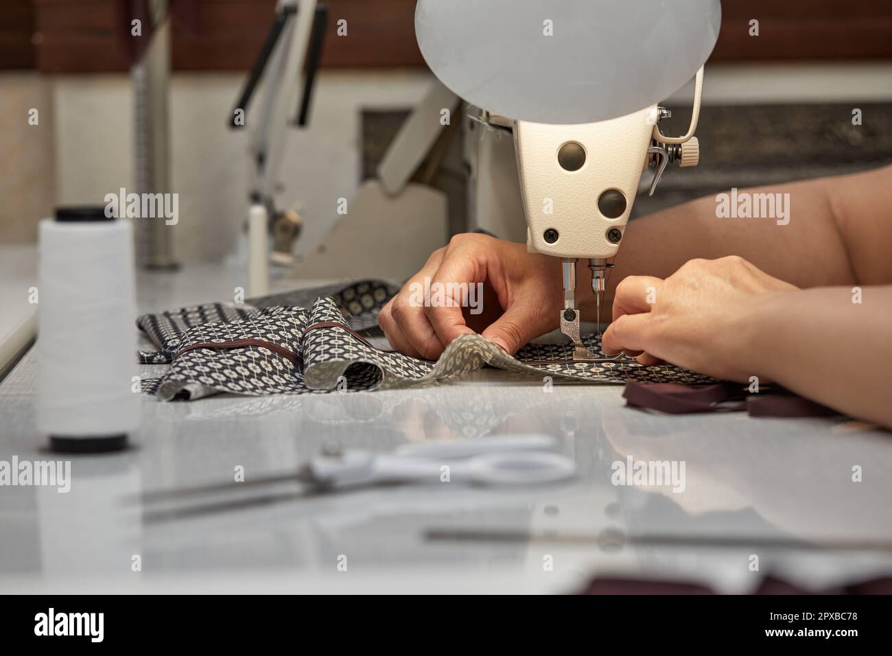 girl seamstress sew on the sewing machine. Women's hands sewing on the ...