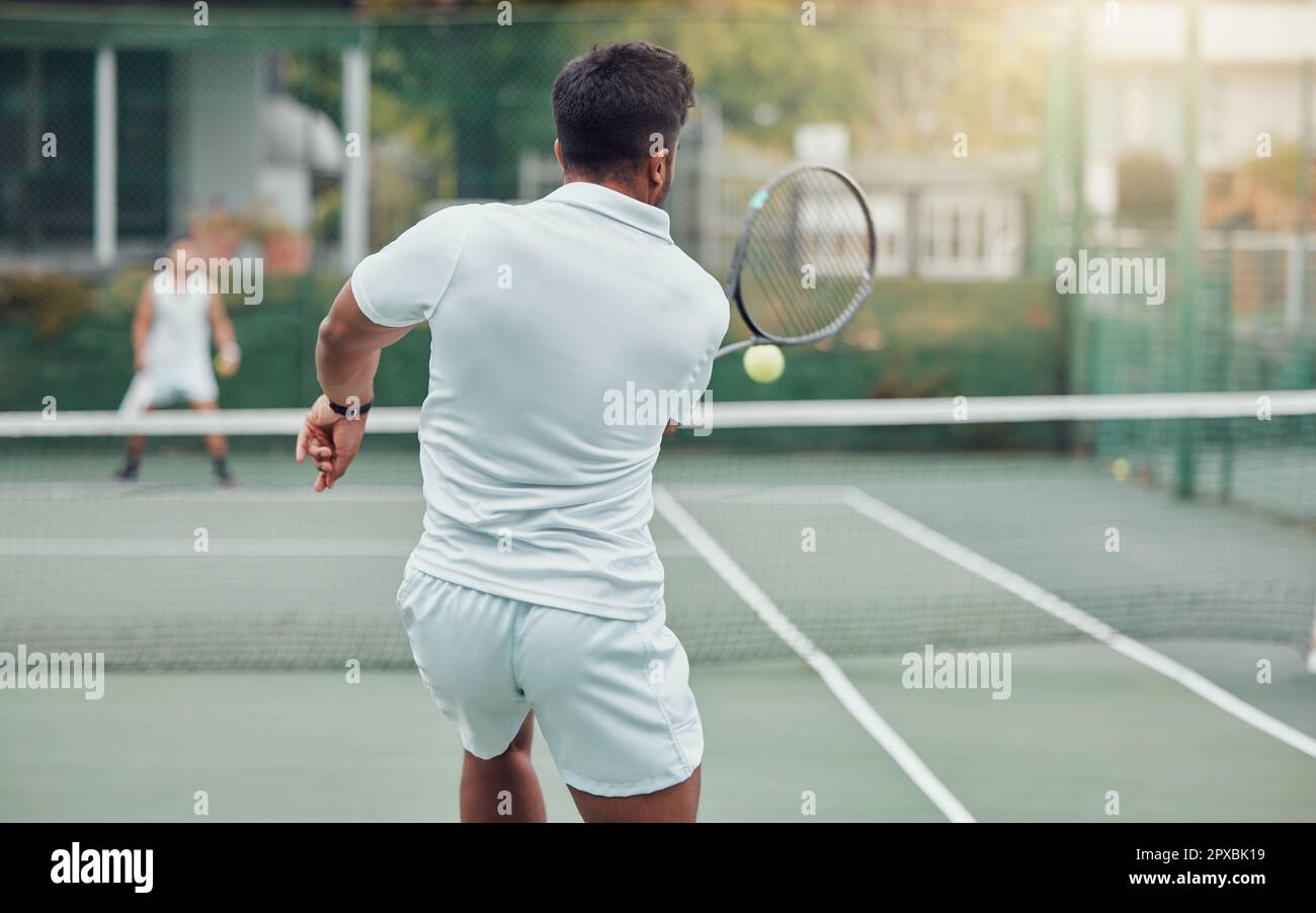 Two ethnic tennis players holding rackets and playing court game. Rear ...
