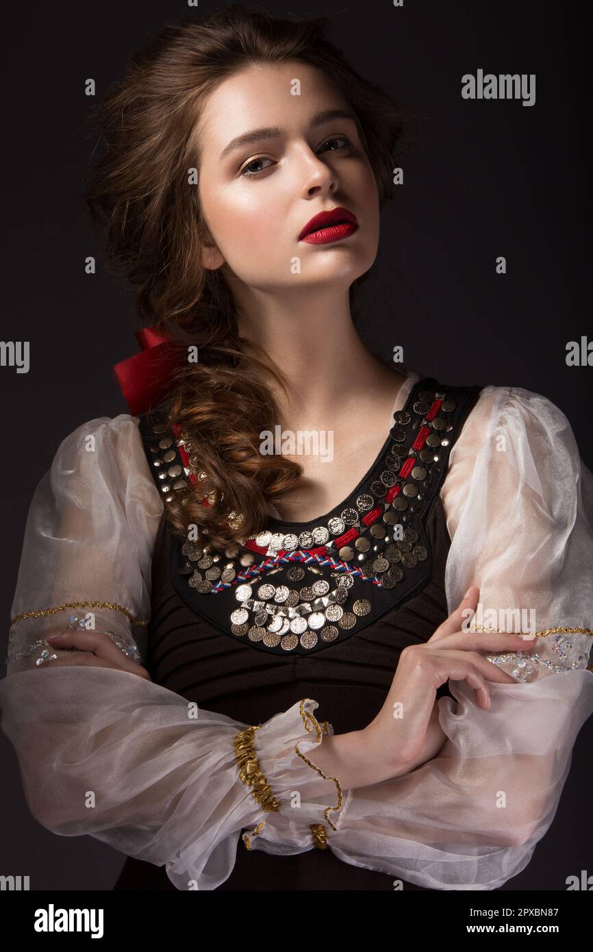 Beautiful Russian girl in national dress with a braid hairstyle and red ...