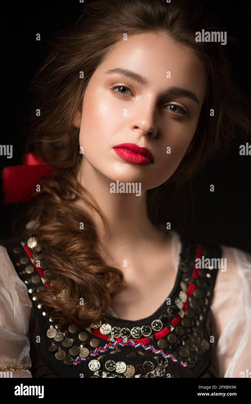 Beautiful Russian girl in national dress with a braid hairstyle and red ...