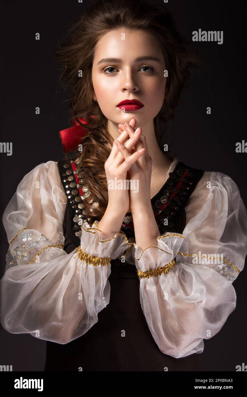 Beautiful Russian girl in national dress with a braid hairstyle and red ...