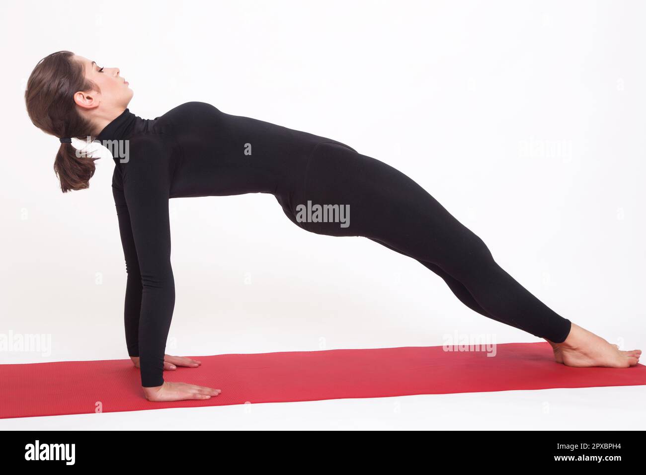 Beautiful athletic girl in black suit doing yoga. Purvottanasana asana ...