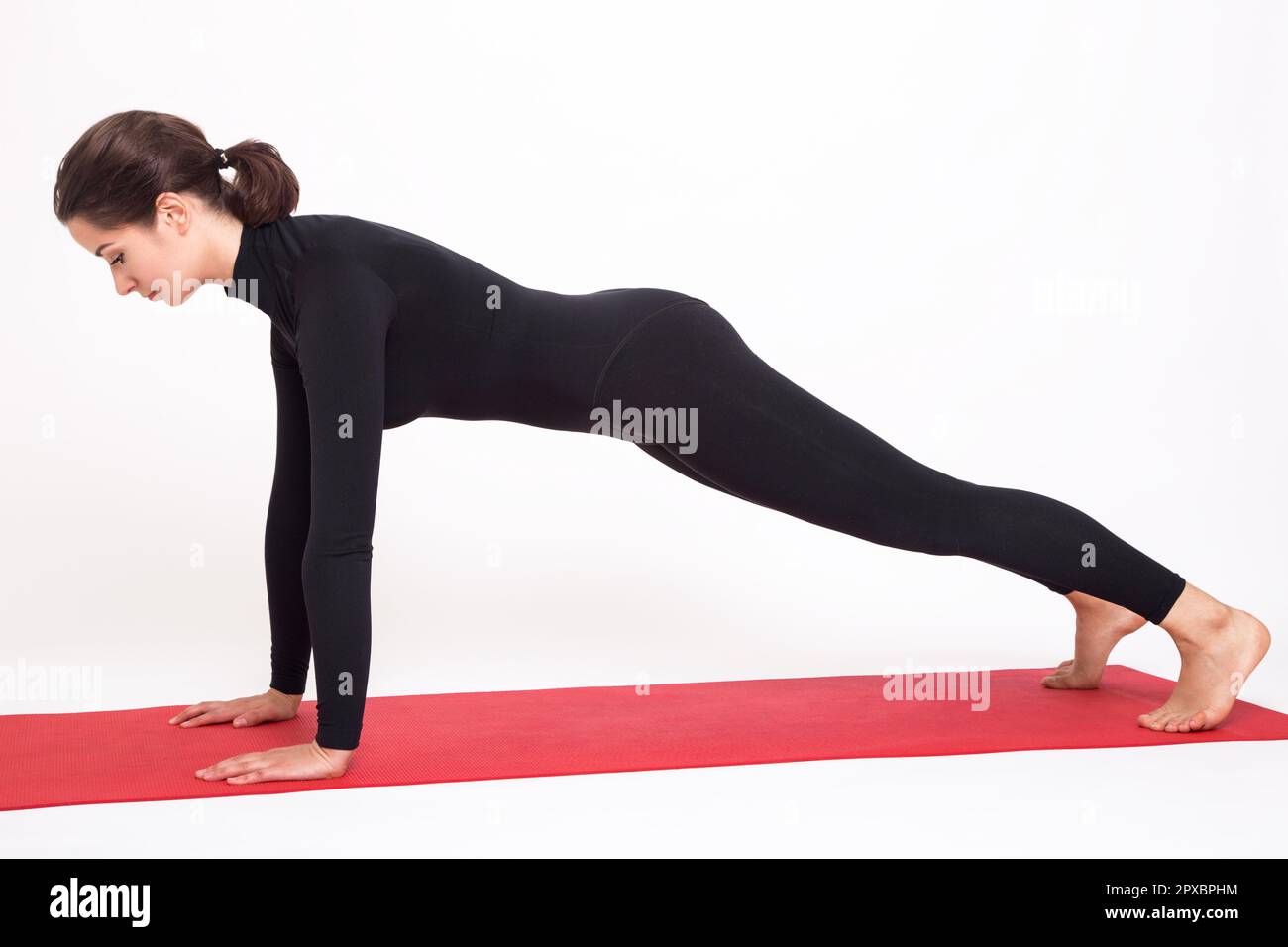 Beautiful athletic girl in black suit doing yoga. Kumbhasana asana ...