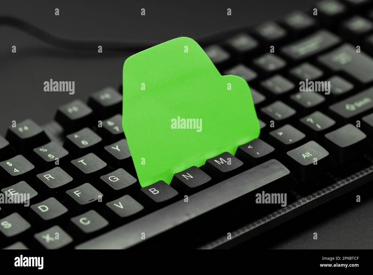 Sticker lying on black keyboard. Important message written over paper ...