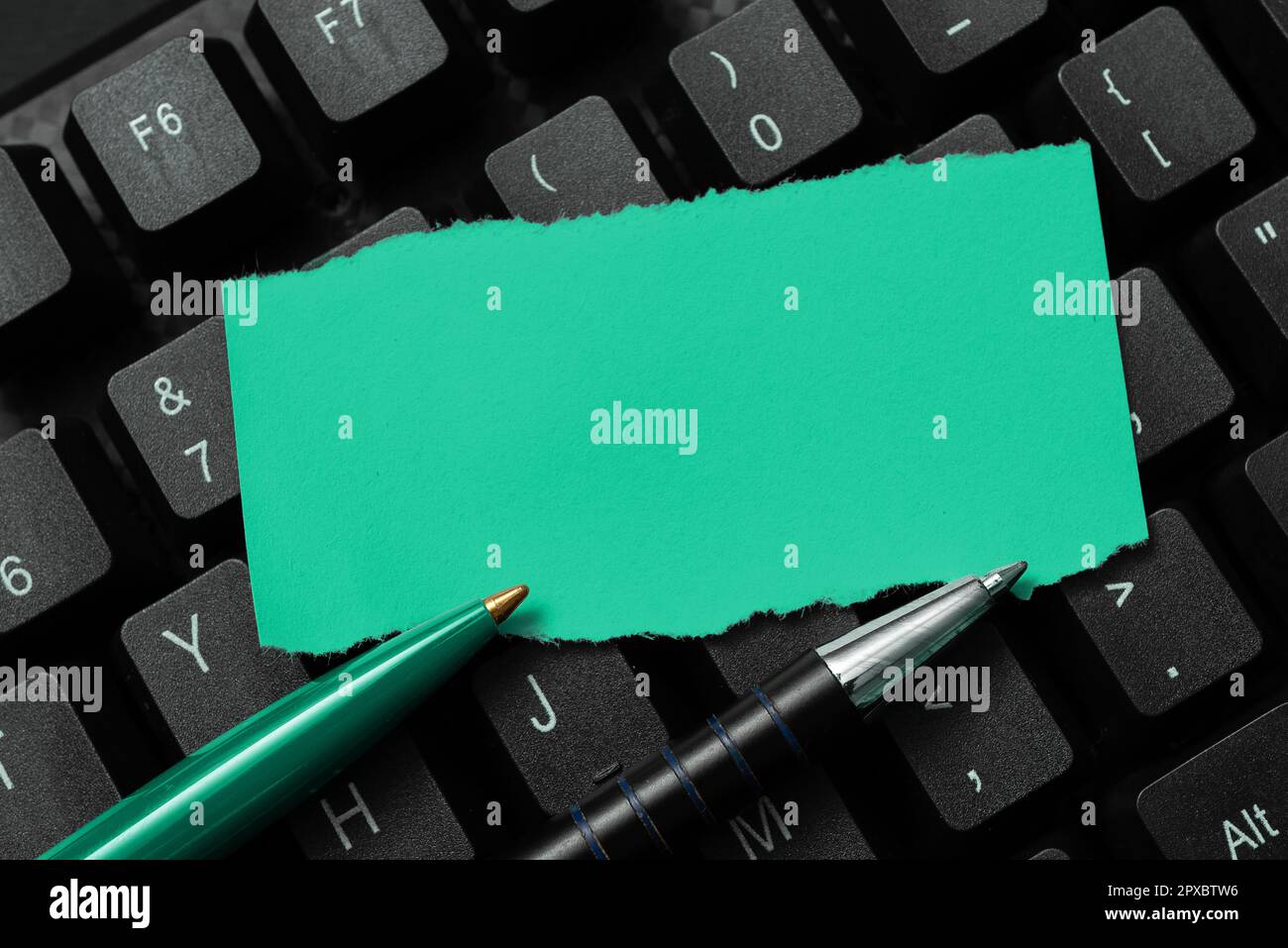 Sticker lying on black keyboard. Important message written over paper ...