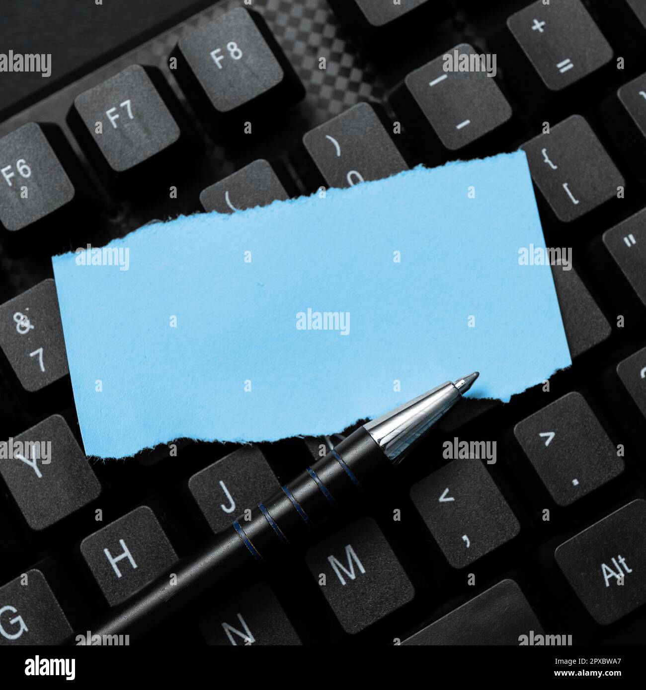 Sticker lying on black keyboard. Important message written over paper ...