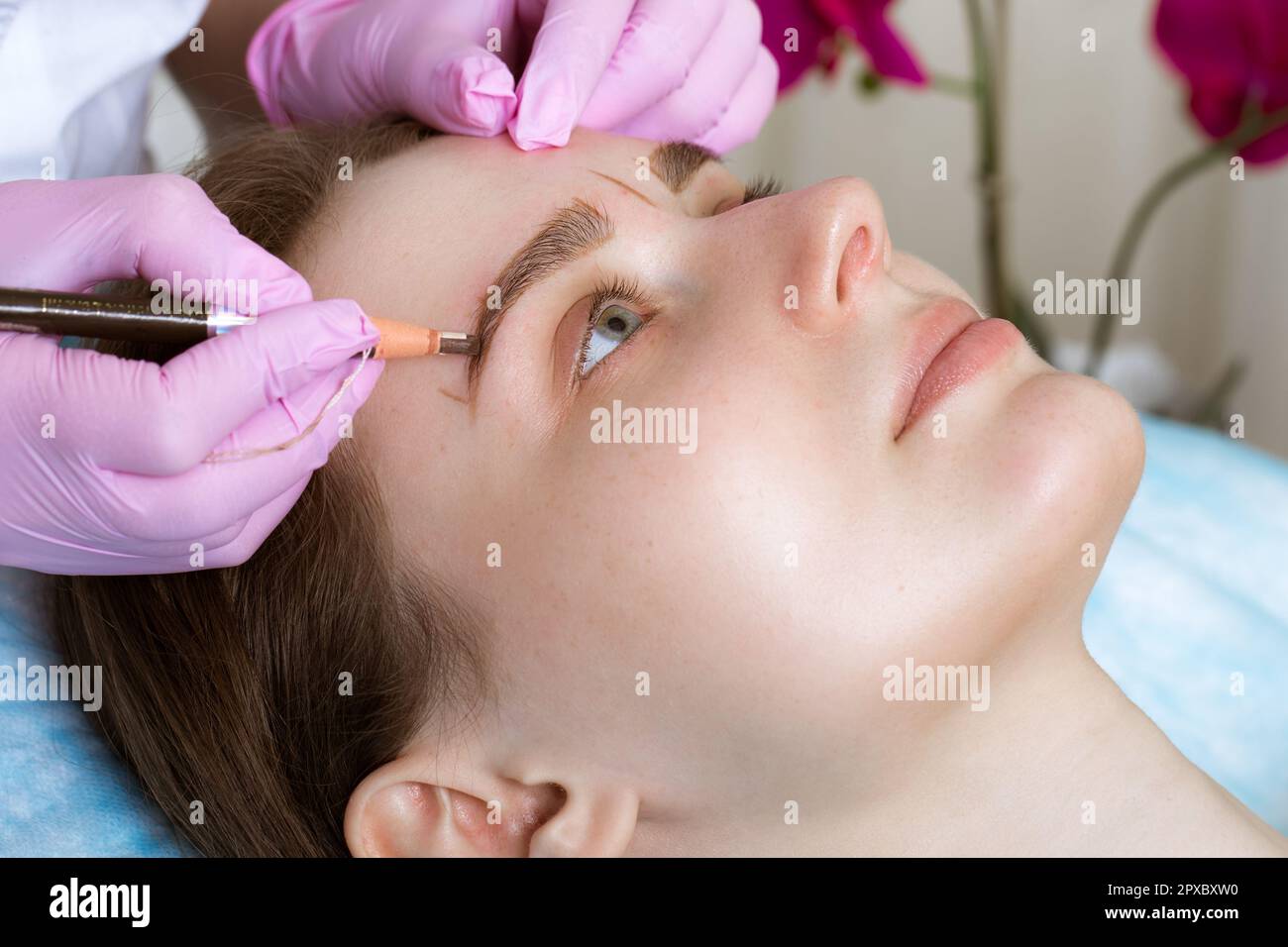 Permanent microblasting tattooing freckles to a woman in a beauty salon ...