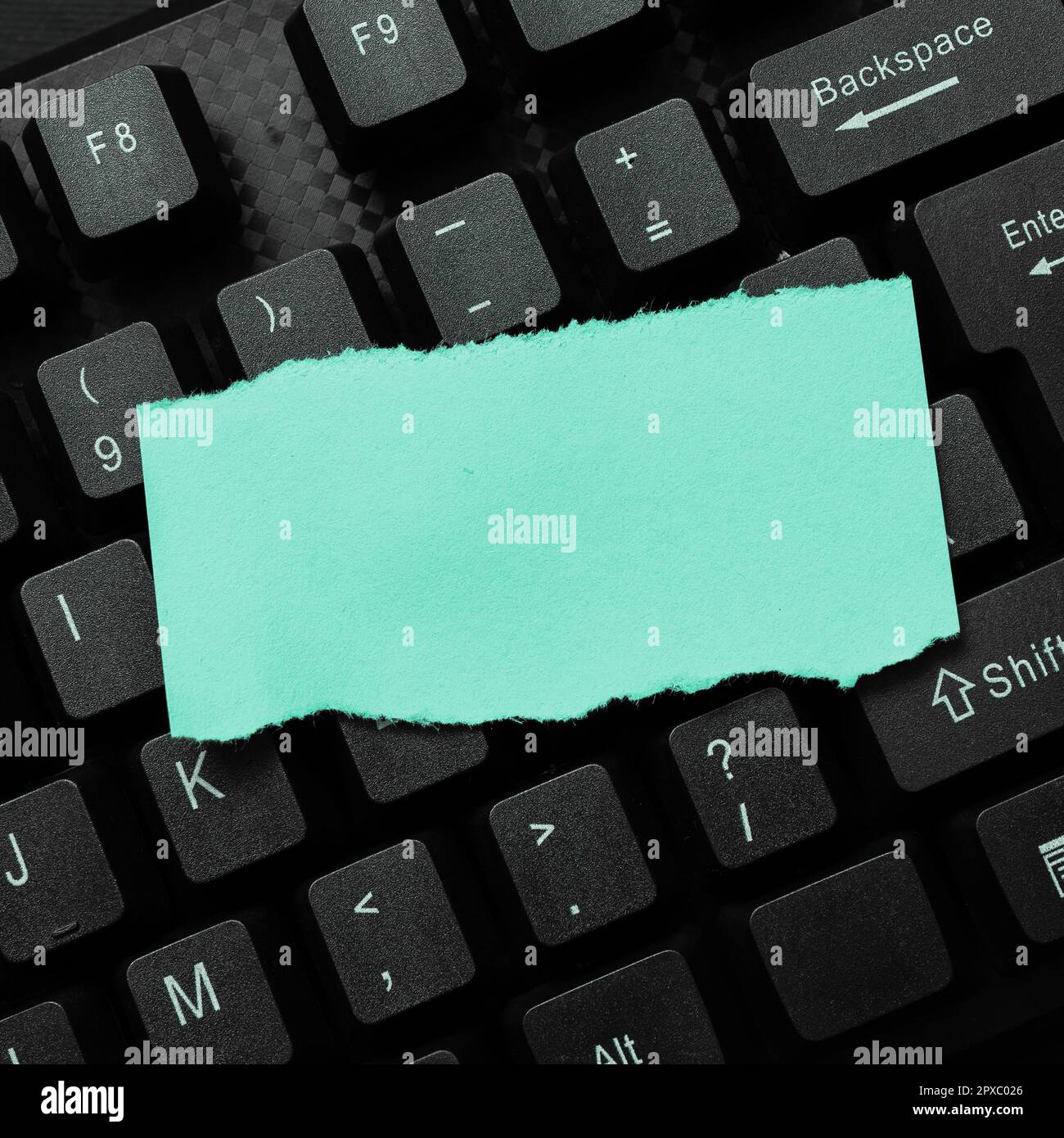 Sticker lying on black keyboard. Important message written over paper ...