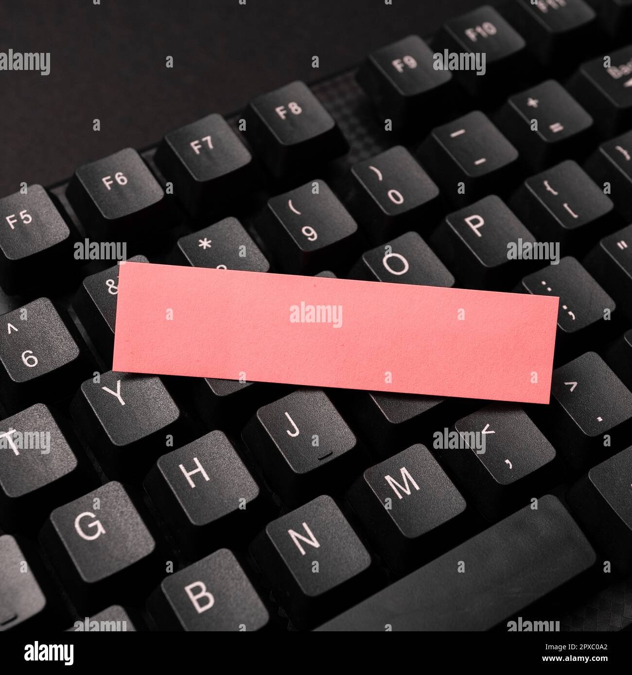 Sticker lying on black keyboard. Important message written over paper ...