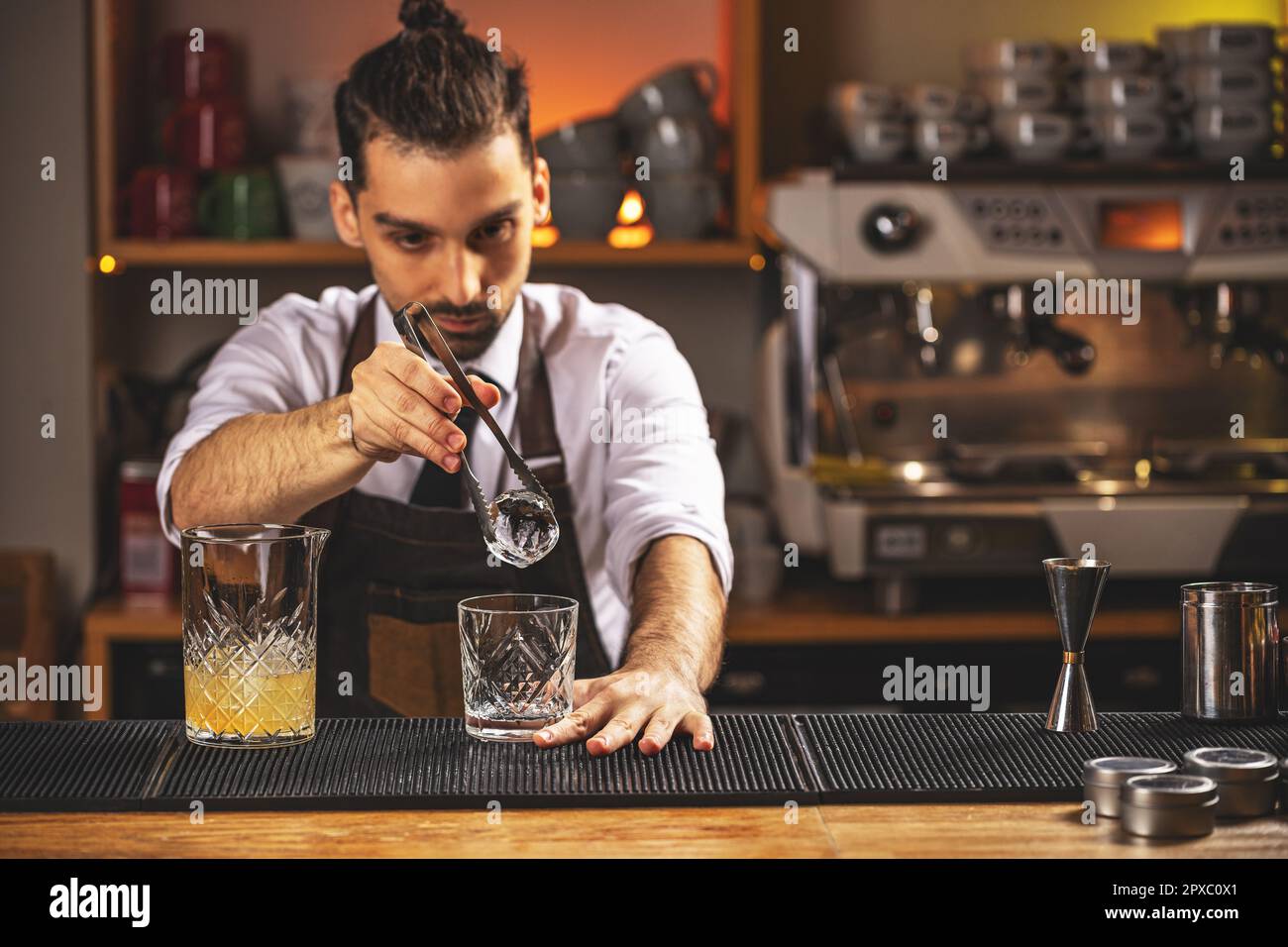 Barman putting ice ball into old fashioned glass Stock Photo - Alamy