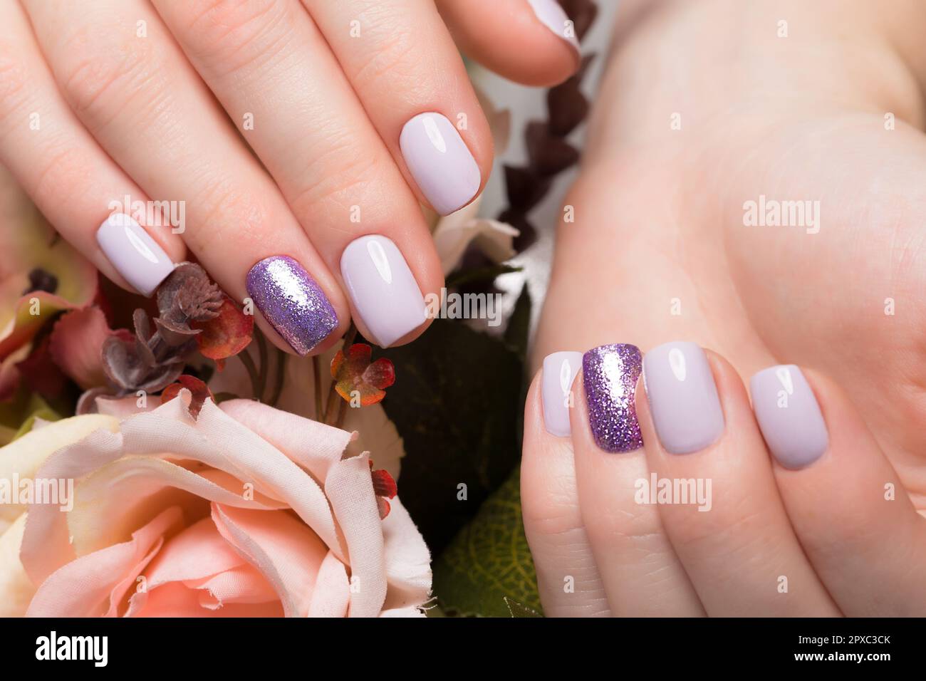 Purple neat manicure on female hands on a background of flowers. Nail ...