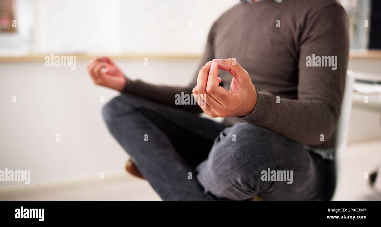 African American Male Meditation In Office Near Computer Stock Photo ...