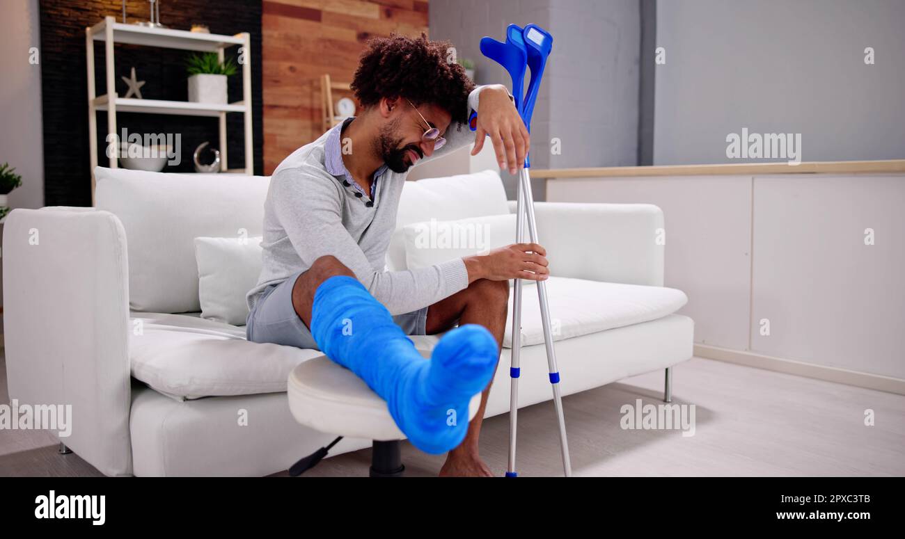 Broken Leg In Cast Recovery. Man With Injury On Sofa Stock Photo - Alamy