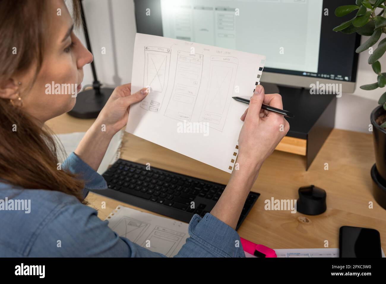 Sketch of wireframe for website. Women designer working on a mobile ...