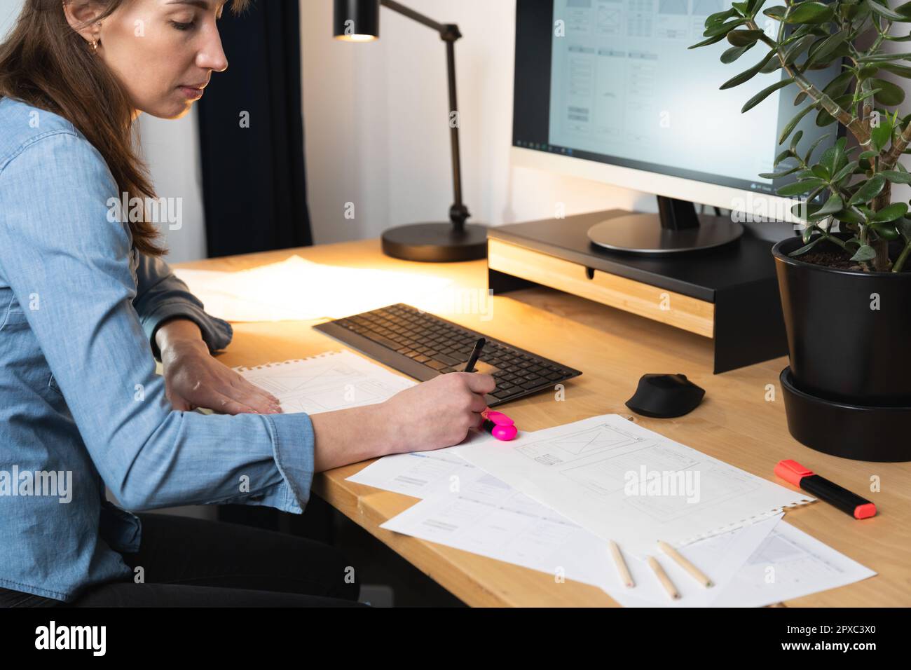 Sketch of wireframe for website. Women designer working on a mobile ...