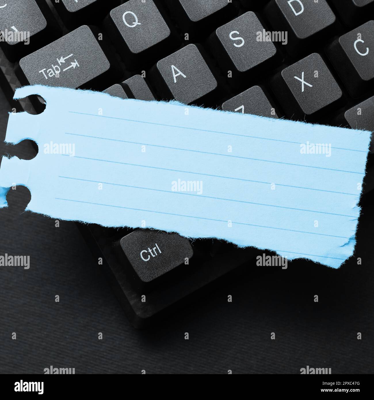 Sticker lying on black keyboard. Important message written over paper ...