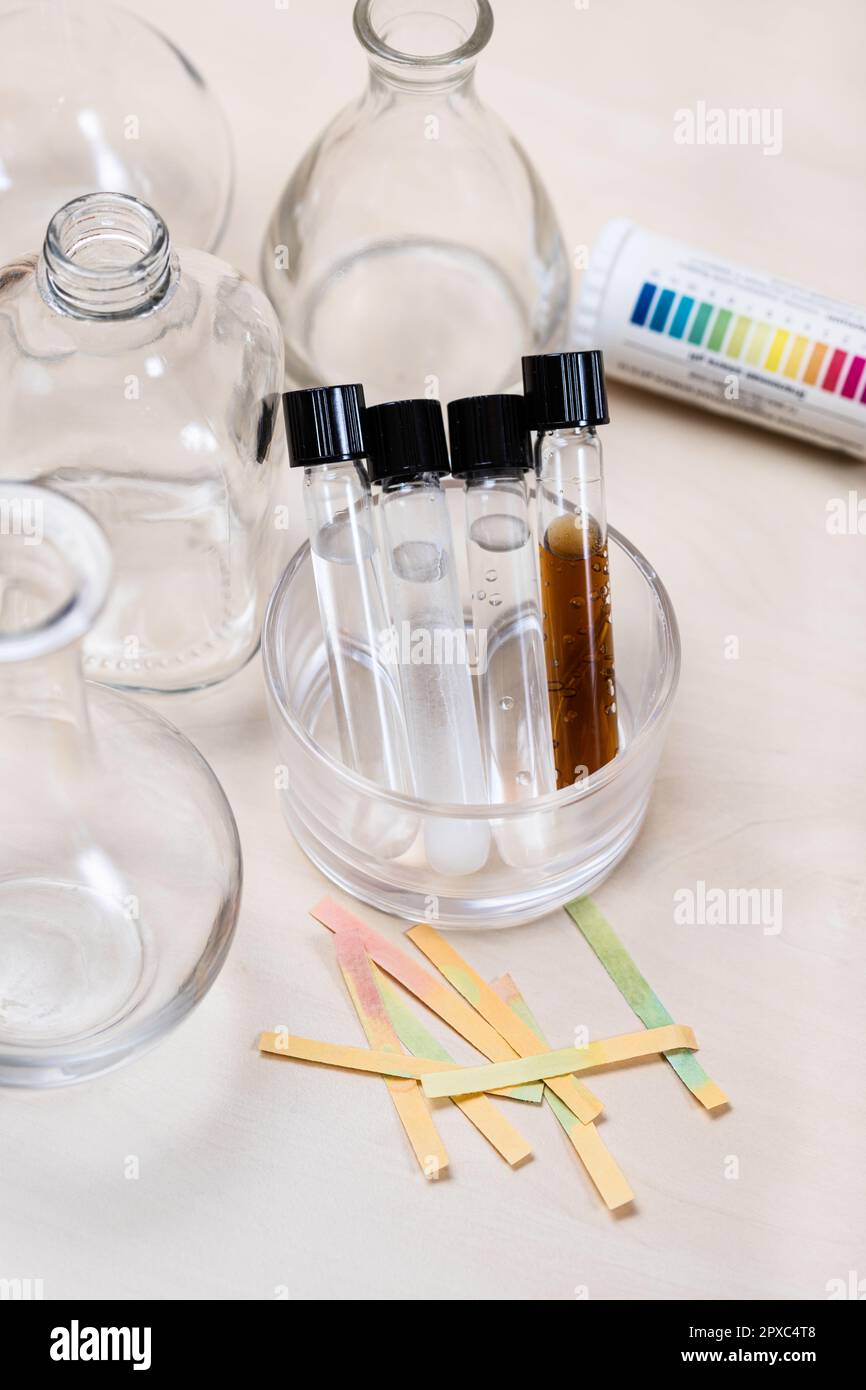 test tubes with various solutions, bottles and used indicators on light ...