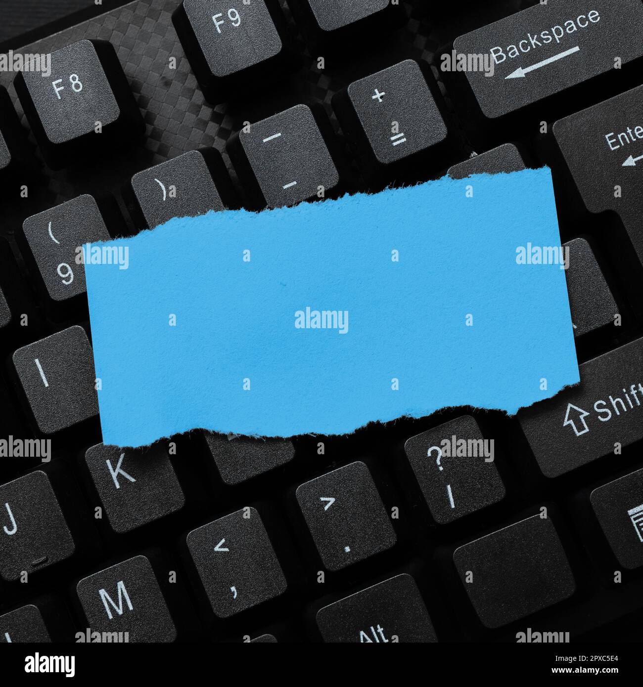 Sticker lying on black keyboard. Important message written over paper ...