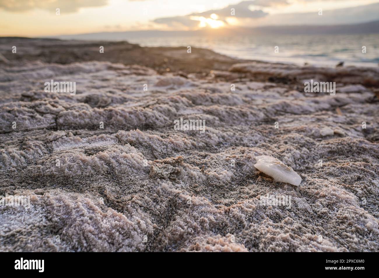 Sand and stones covered with crystalline salt on shore of Dead Sea ...