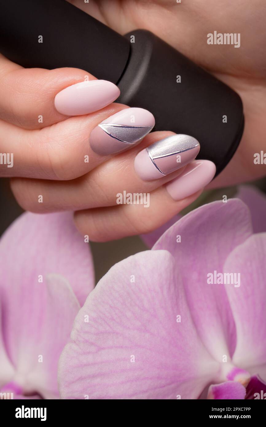 Purple neat manicure on female hands on a background of flowers. Nail ...