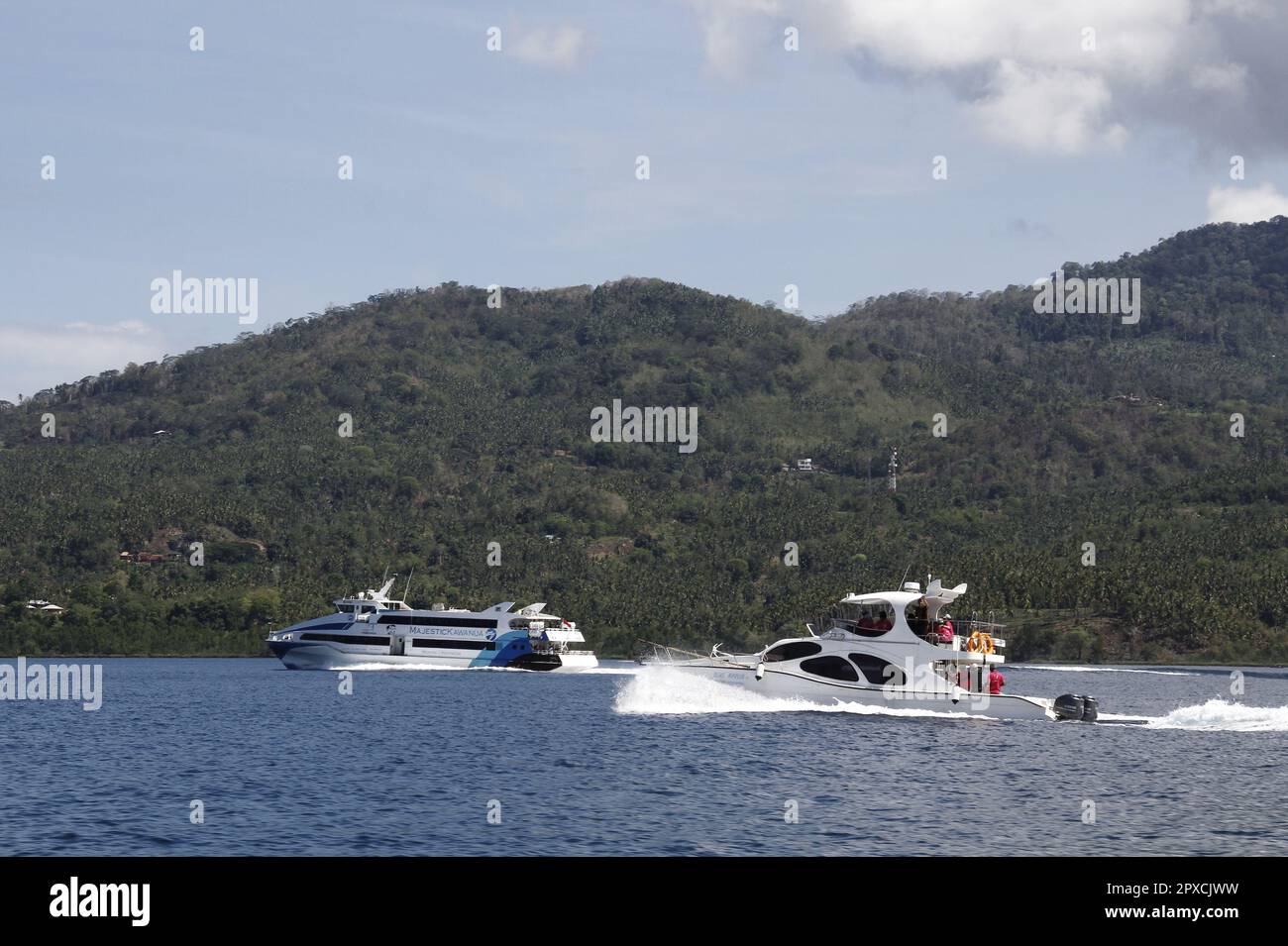 Fast ship sailing with hills in the background Stock Photo - Alamy