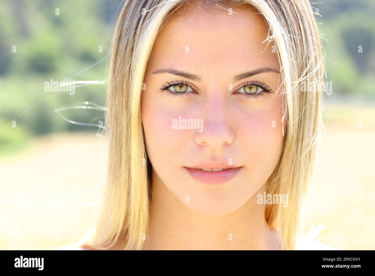 Front view portrait of a beautiful woman with green eyes looks at ...