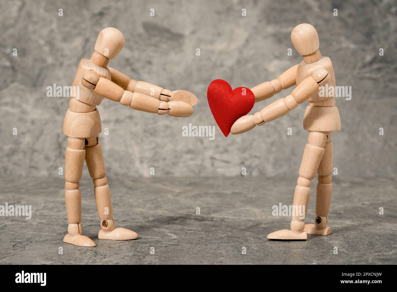 Dummy giving a red heart to other dummy. Man declaring his love to a ... Dummy giving a red heart to other dummy. Man declaring his love to a ...
