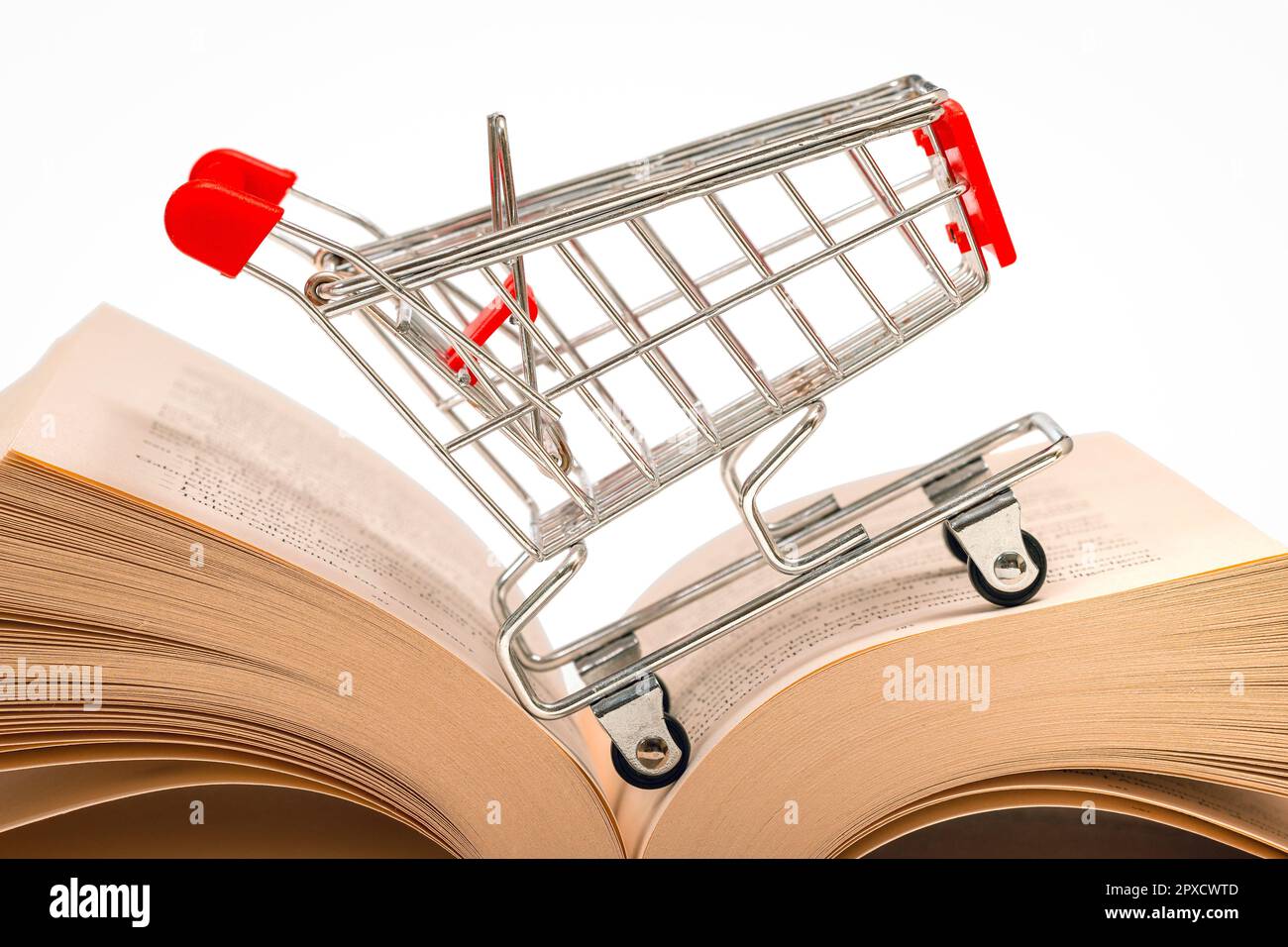 An empty shopping cart stands on the open book pages. The concept of ...