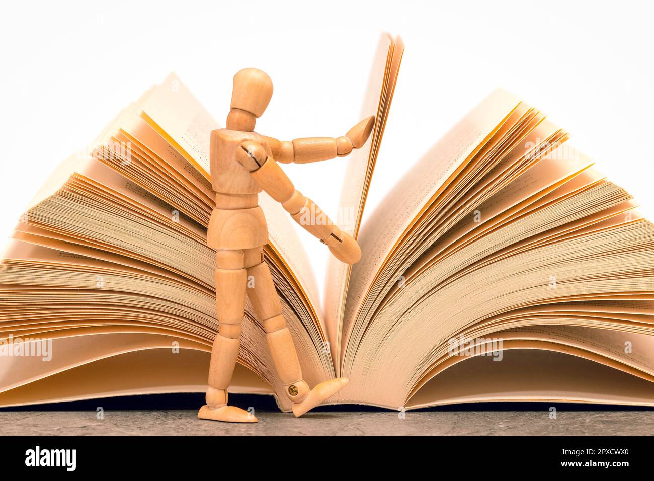 Wooden mannequin turning the pages of a book. Love reading concept ...