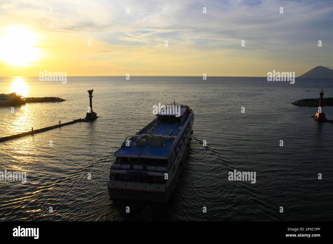 Ship out of harbor at sunset, sailing on calm seas Stock Photo - Alamy