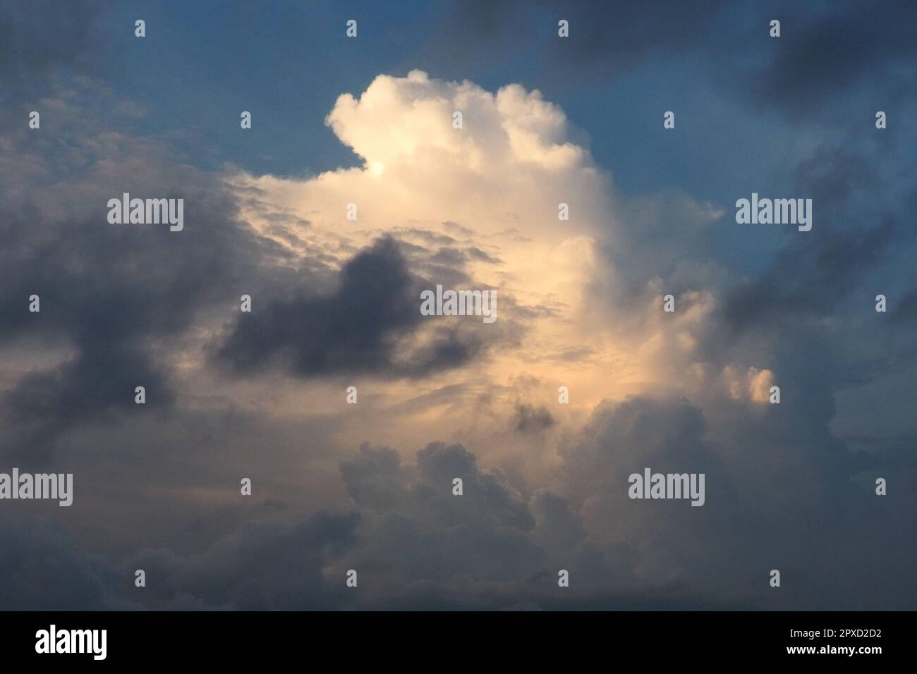 A beautiful cloud illuminated by sun during sunset. Blue sky and dark ...