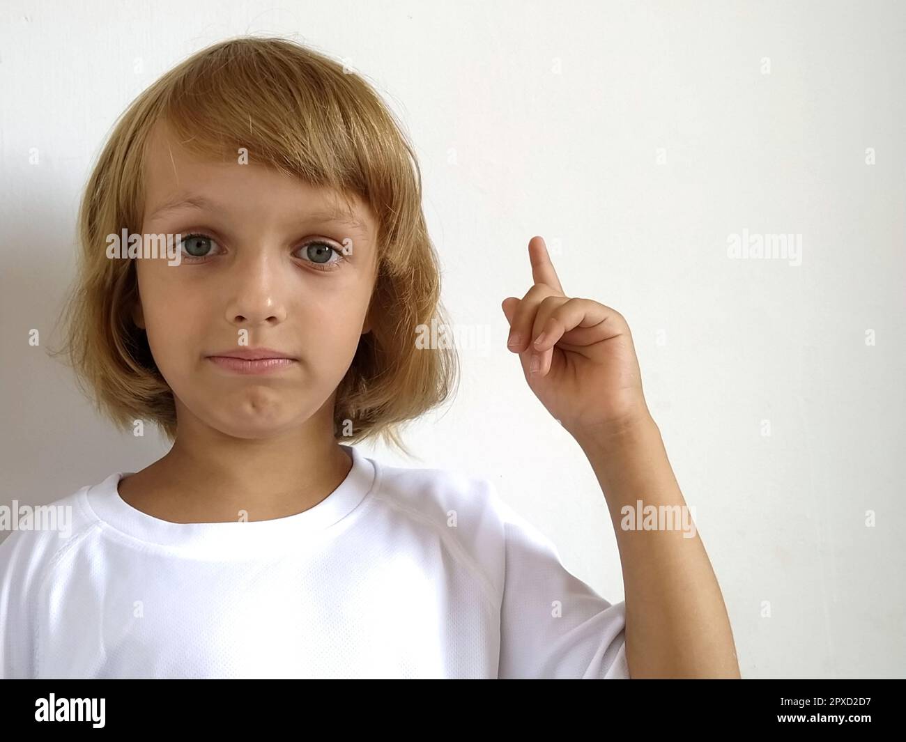A little cute girl 6-7 years old with blond hair on a white background ...