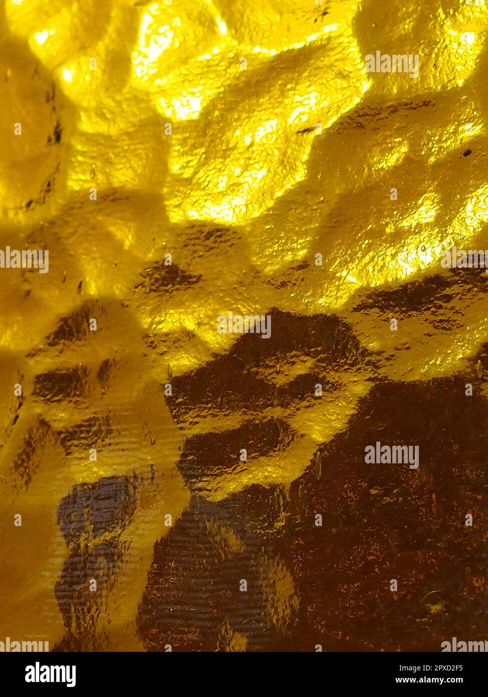 golden yellow corrugated glass with a light and dark background ...