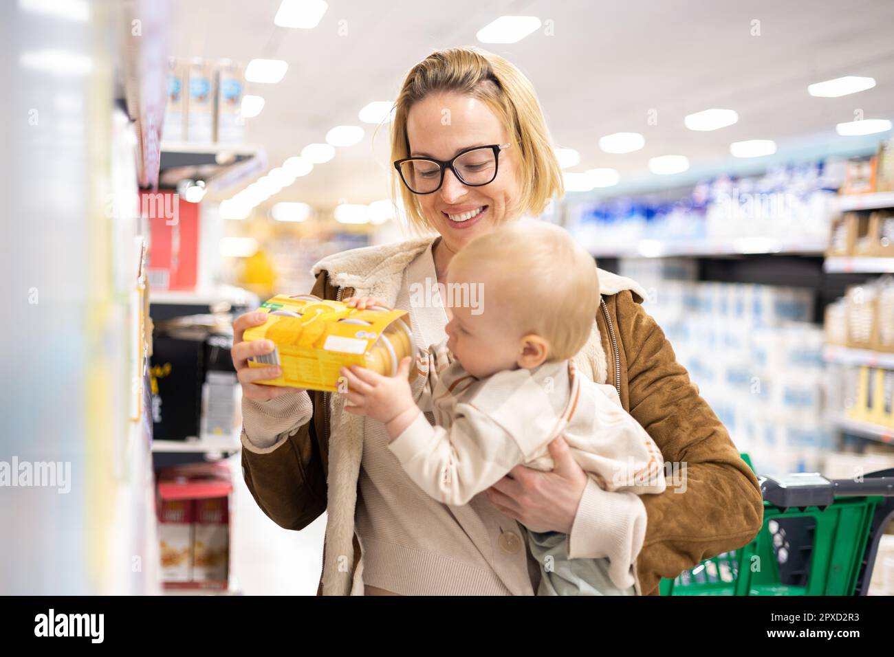 Caucasian mother shopping with her infant baby boy child choosing ...