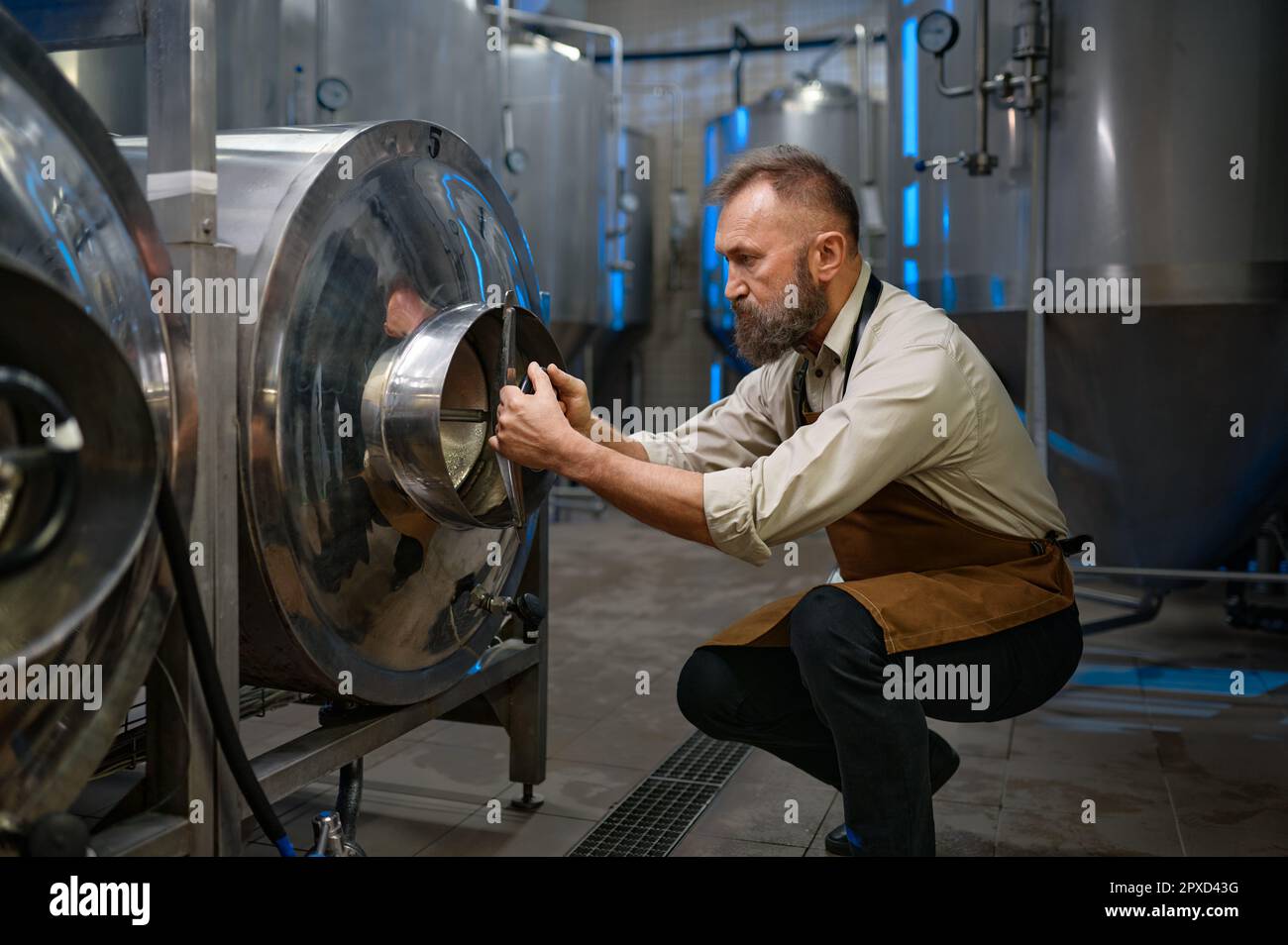 Concentrated brewer working with metallic vats twisting lid to open ...