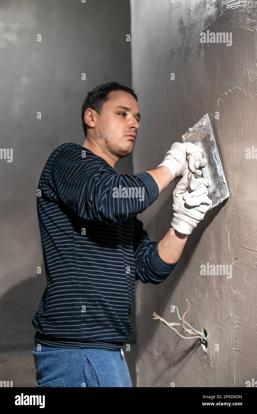 man applies insulation to a bathroom wall Stock Photo - Alamy