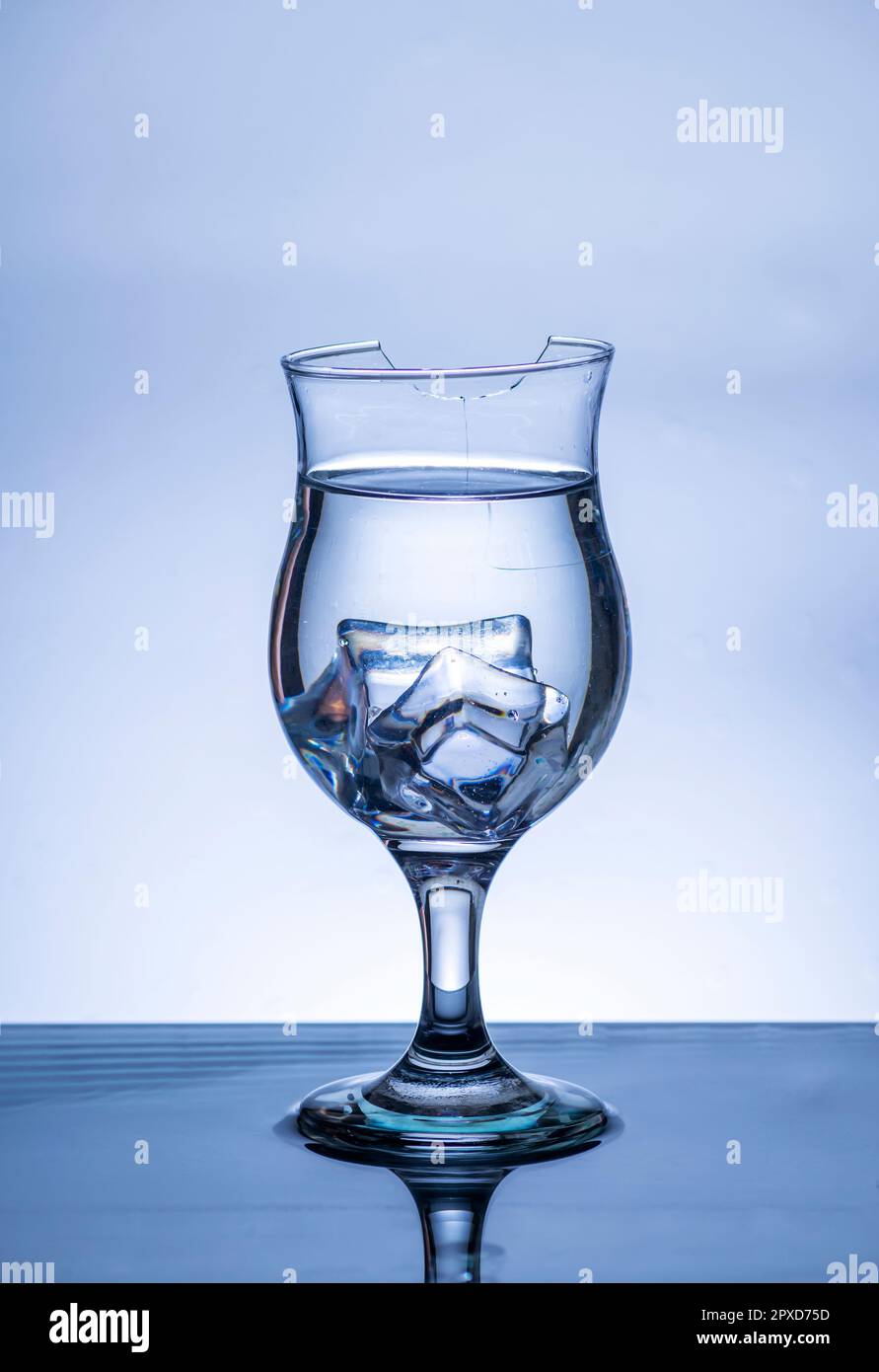 The image of pouring drinking water, into a broken glass, that makes ...