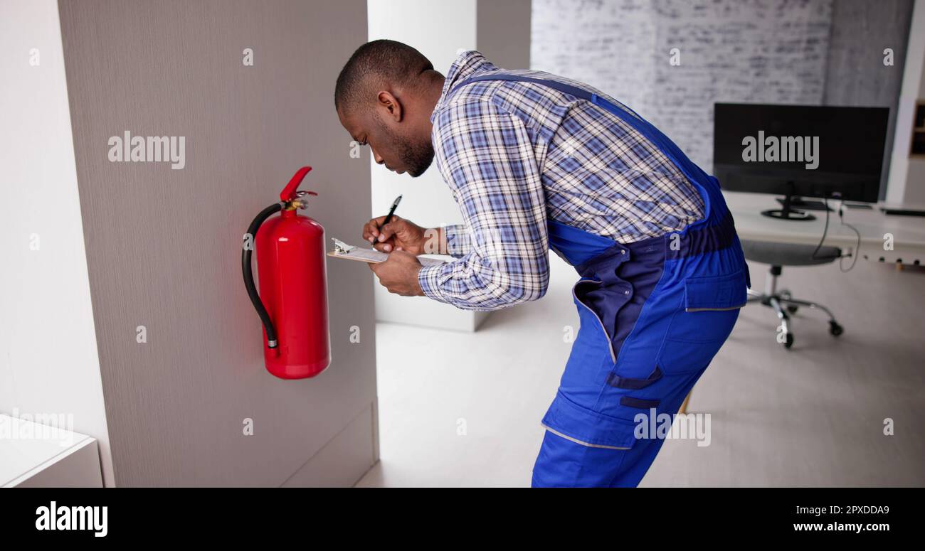 Checking Fire Extinguisher. Safety And Emergency Prevention Stock Photo ...