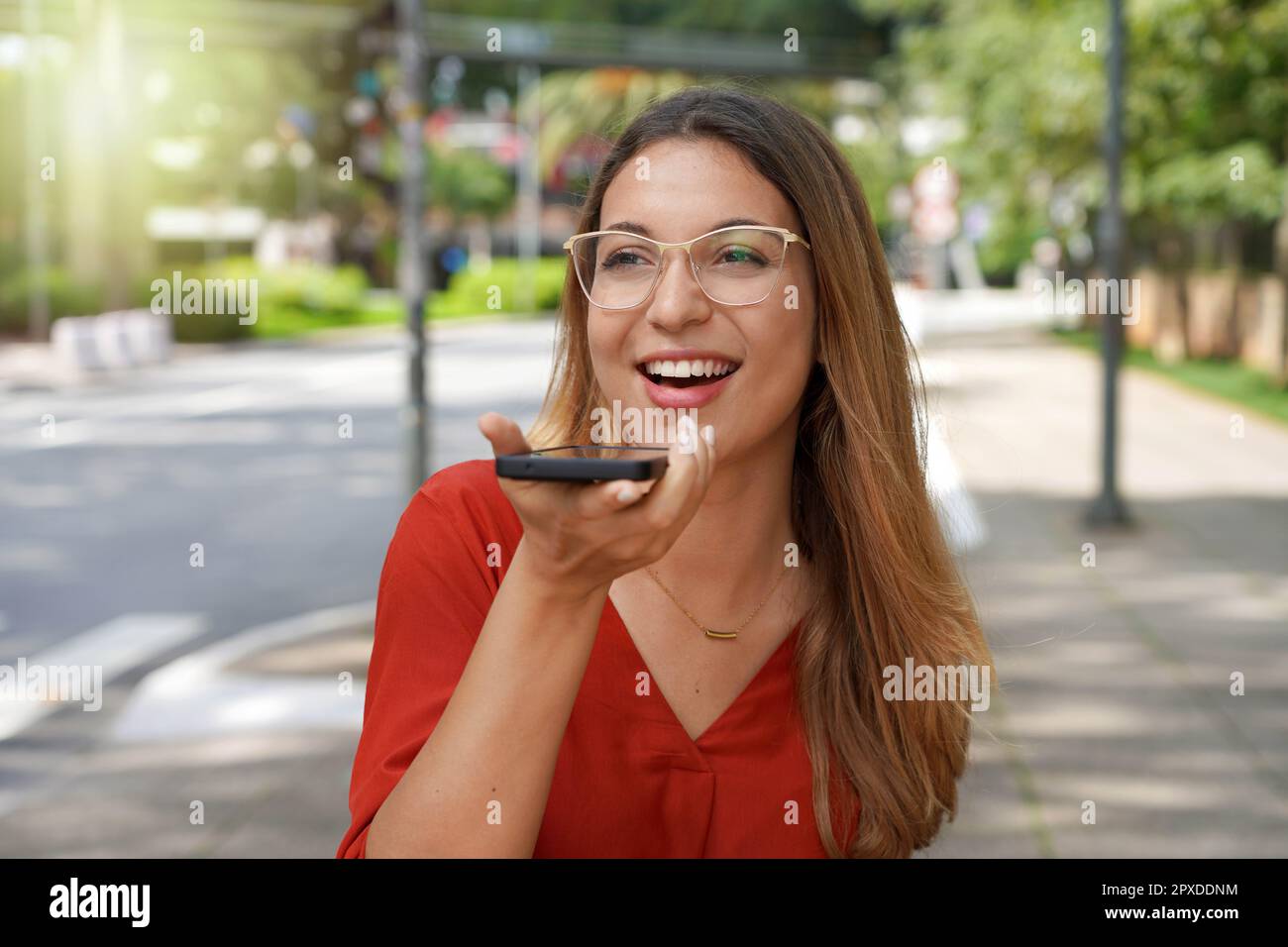 Brazilian student girl recording voice message on smartphone, talking ...