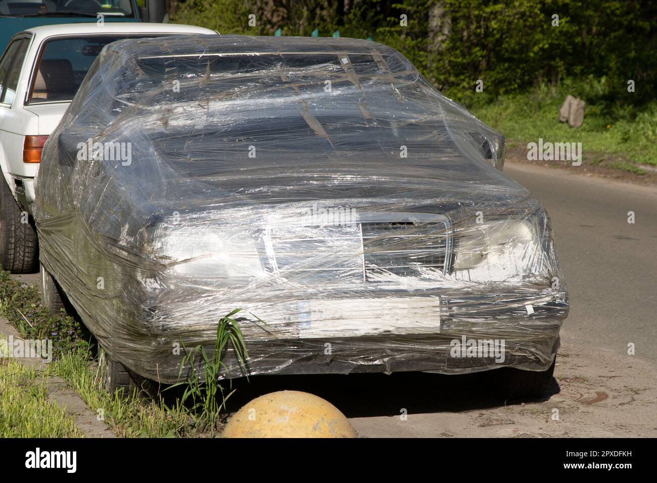 The passenger car is packed in a plastic bag made of stretch film and ...