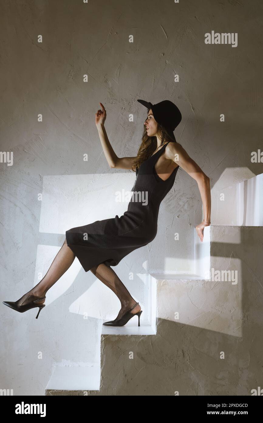 Beautiful woman is balancing on concrete stairs to not fall down on ...