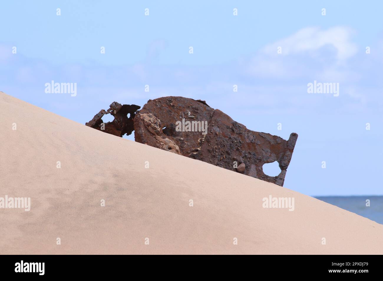 Rusty metal part washed up on beach Stock Photo - Alamy